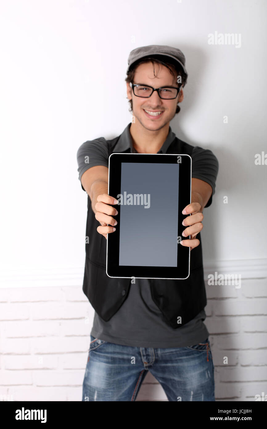 Smart guy showing tablet screen toward camera Stock Photo - Alamy