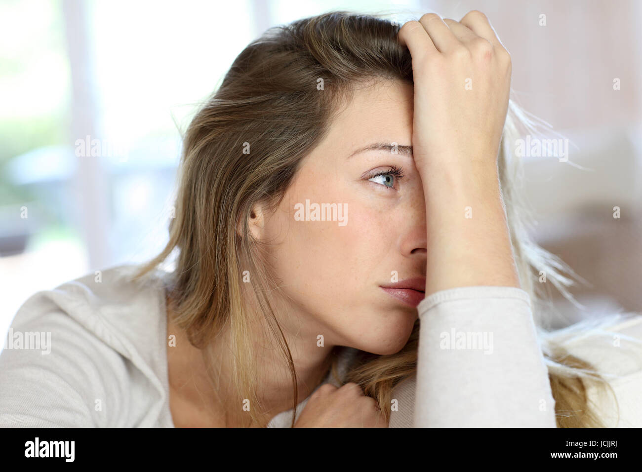 Portrait of blond woman with sad look Stock Photo - Alamy