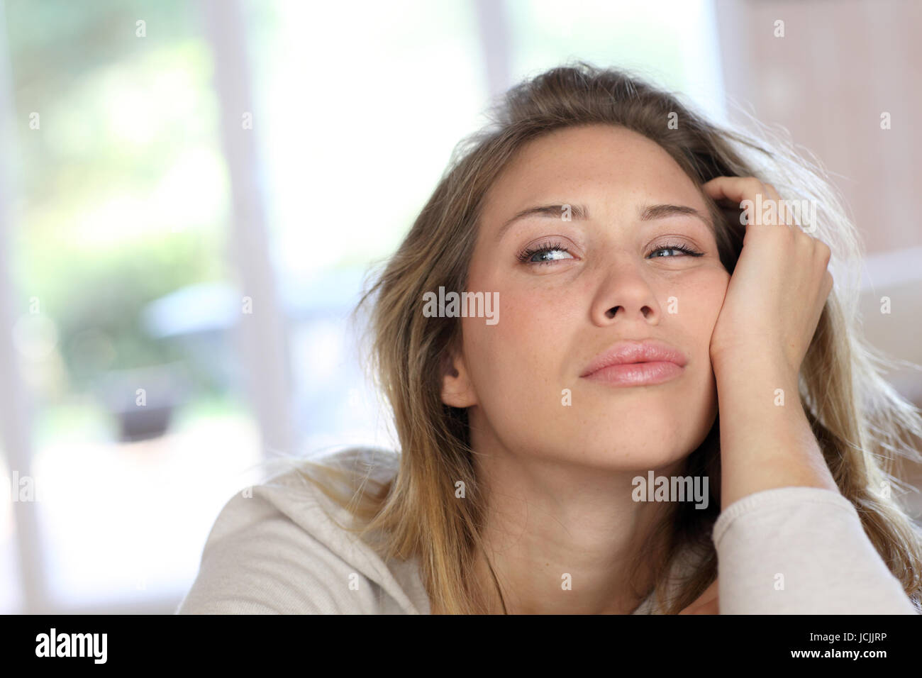 Portrait of blond woman with tired look Stock Photo - Alamy