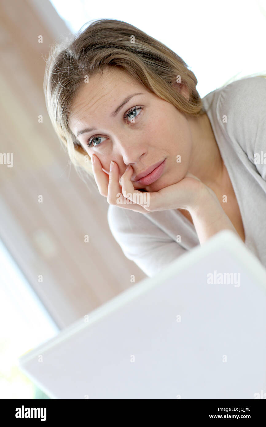 Active woman in front of laptop with upset look Stock Photo - Alamy