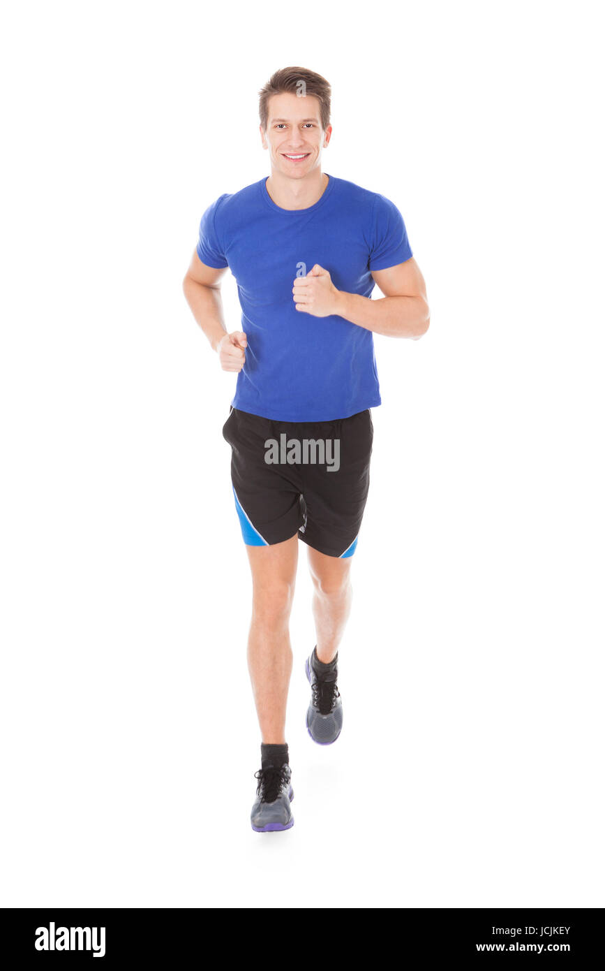 Portrait Of Young Man Jogging On White Background Stock Photo - Alamy