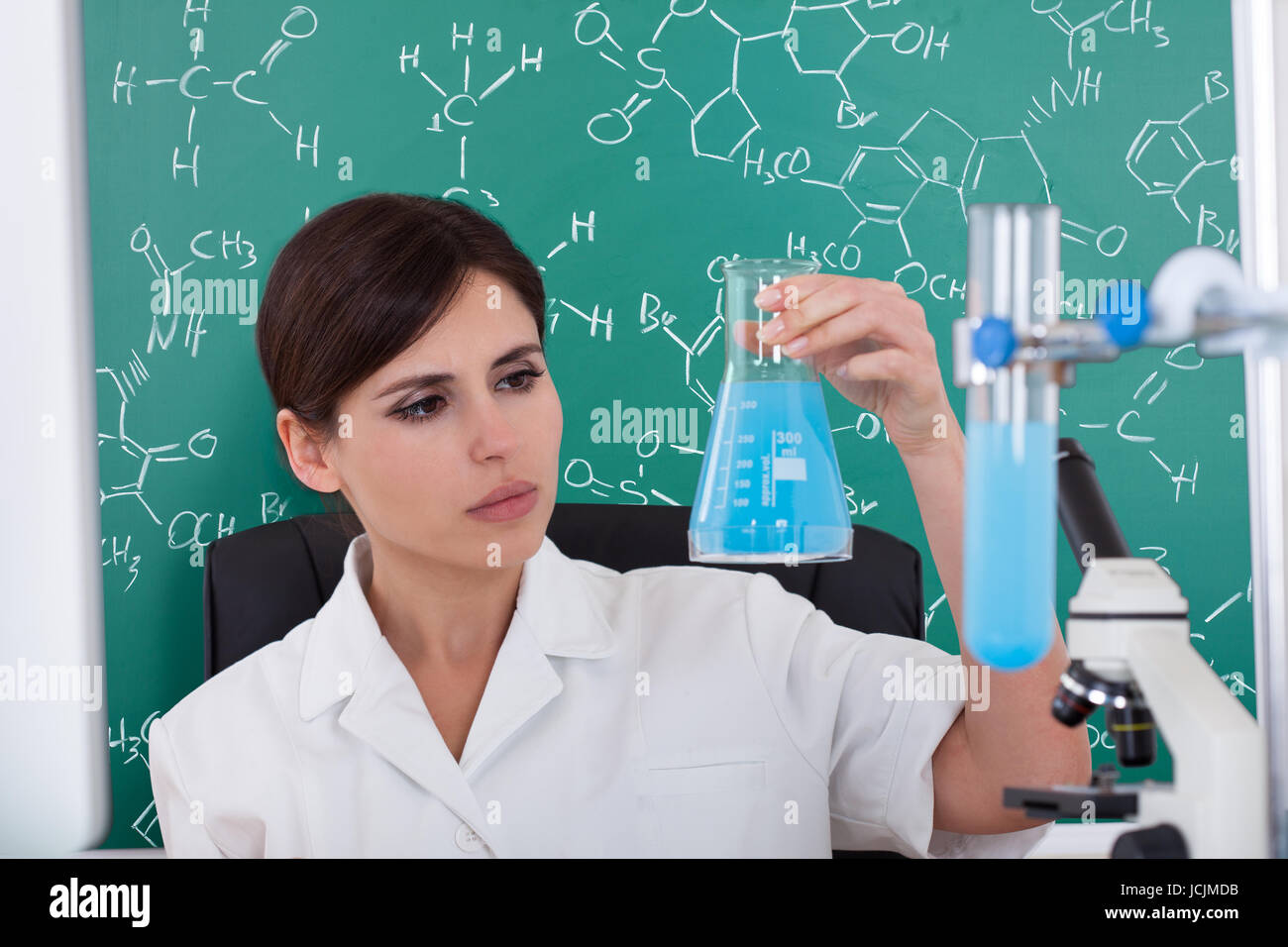 Female Scientist Looking At Chemical In Flask Stock Photo - Alamy