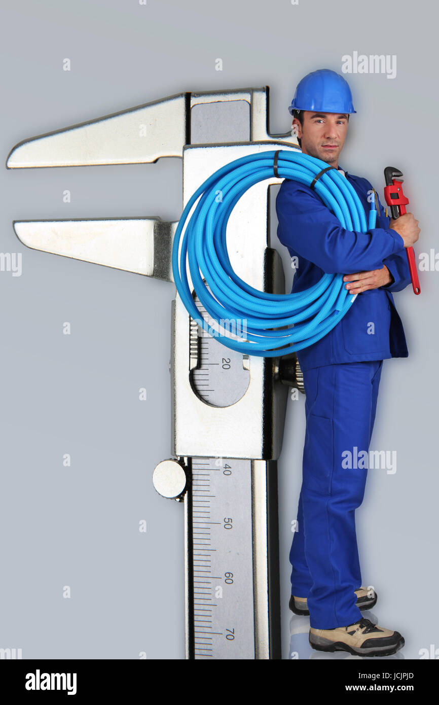 Plumber next to giant calliper Stock Photo - Alamy