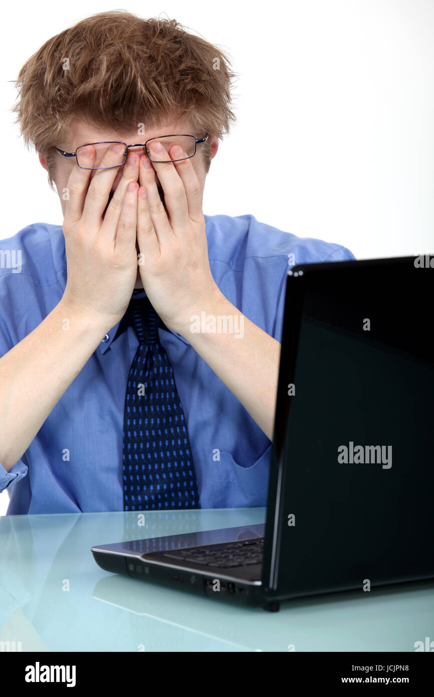 A stressed out man in front of his laptop Stock Photo - Alamy