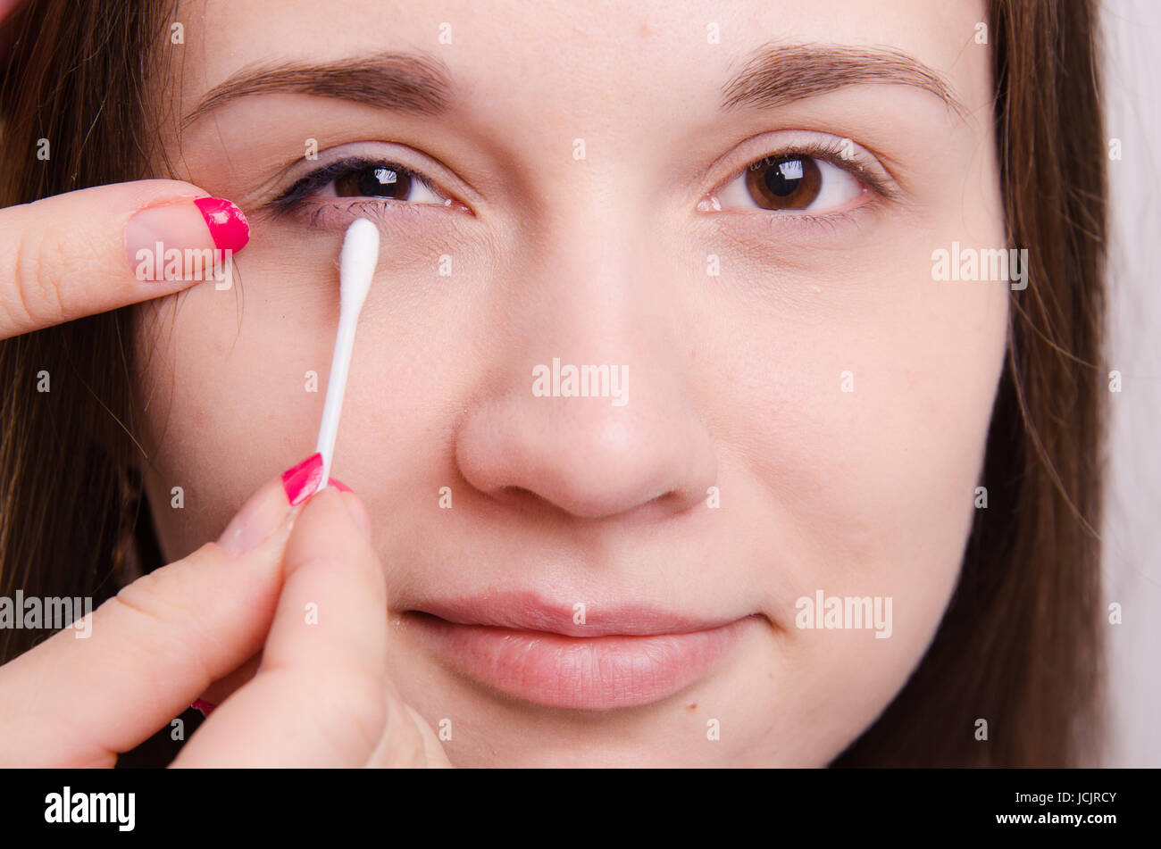 Makeup artist paints the eyelids of a beautiful young girl in the ...