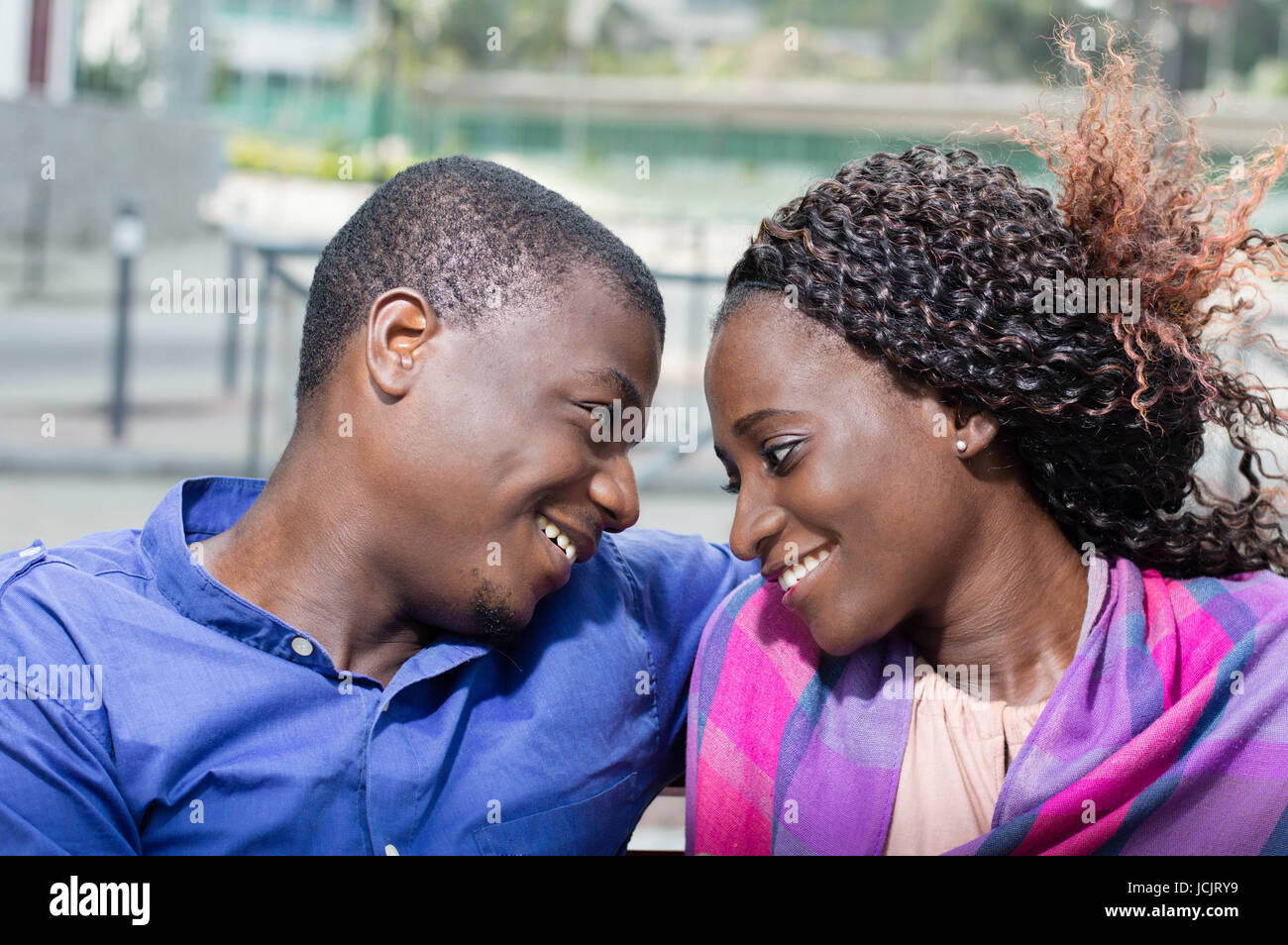 young people sitting face to face, look into their eyes with a smile ...