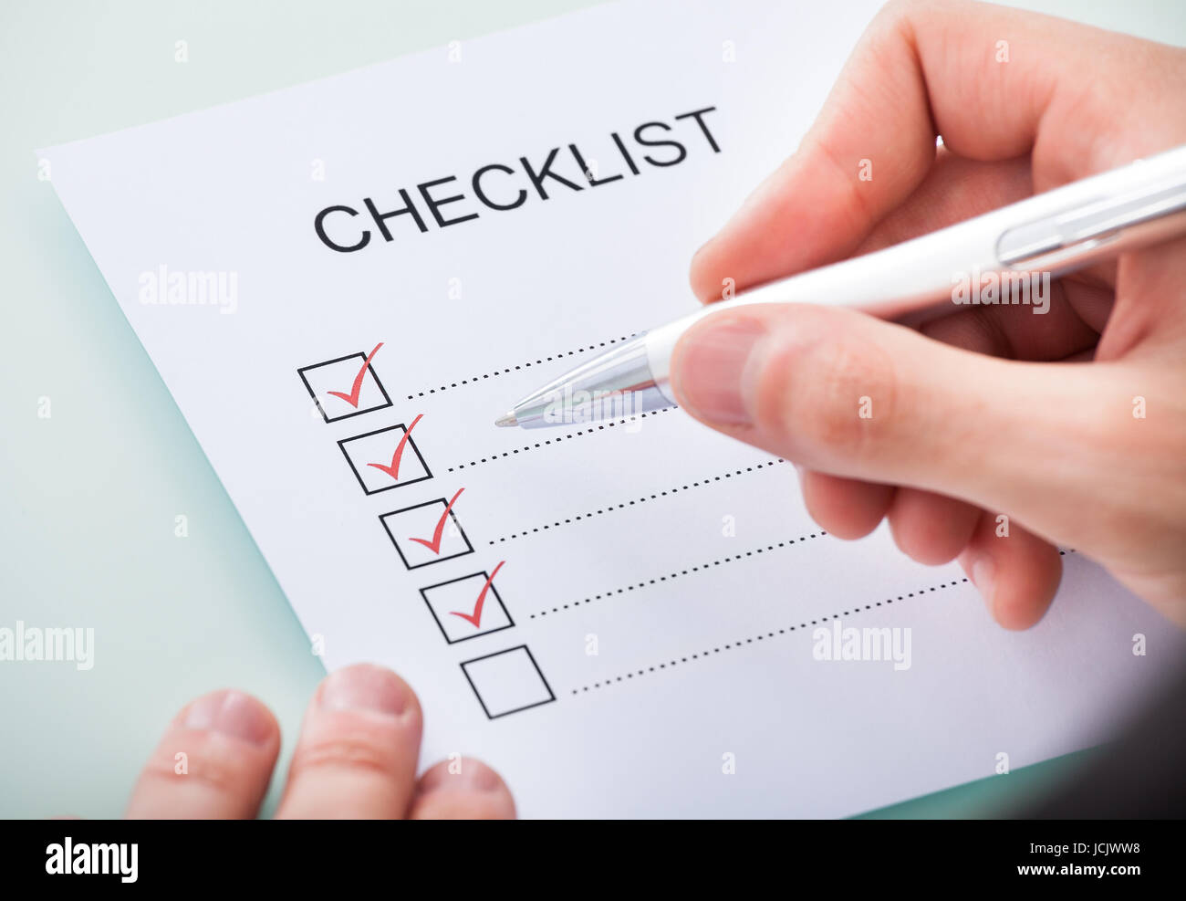 Close-up Of A Person's Hand Marking On Checklist With Pen Stock Photo ...