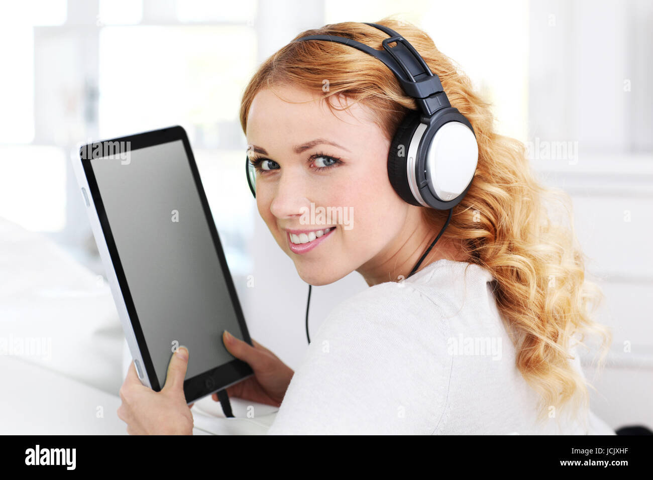 Portrait of woman with tablet and headphones Stock Photo - Alamy