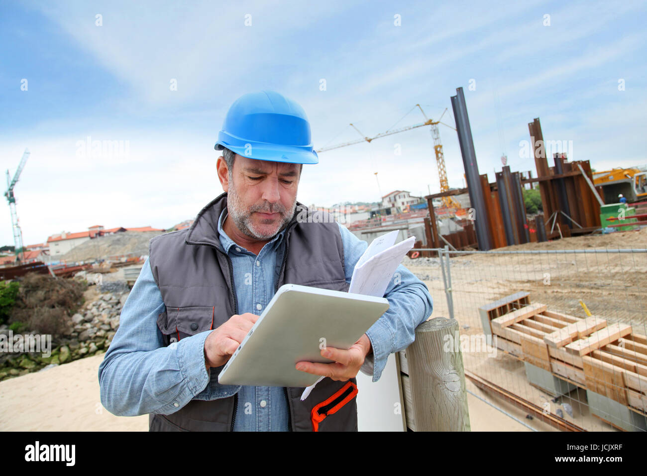 Construction manager controlling building site with plan Stock Photo ...
