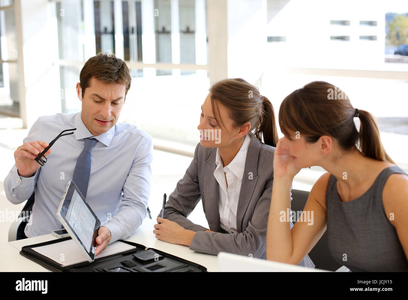 Business presentation around table Stock Photo - Alamy