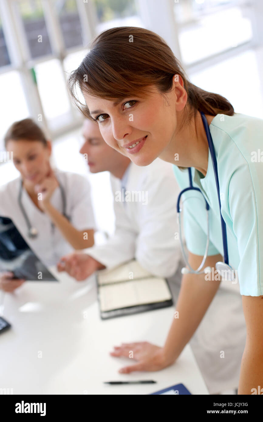 Attractive nurse working in hospital, people in background Stock Photo ...