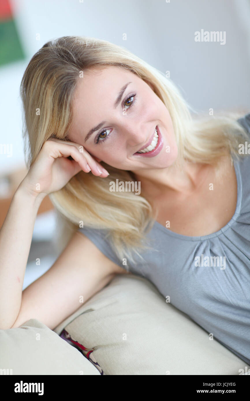 Beautiful smiling woman relaxing in sofa Stock Photo - Alamy