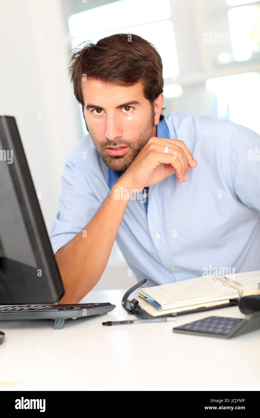 Office worker sitting at his desk Stock Photo - Alamy
