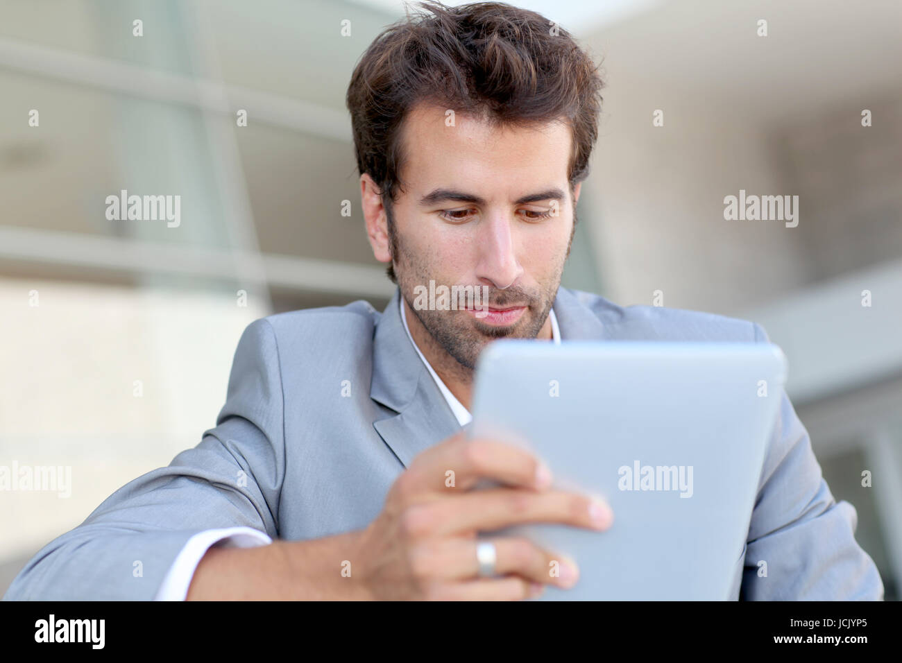 Portrait of smiling man using electronic tablet outside Stock Photo - Alamy