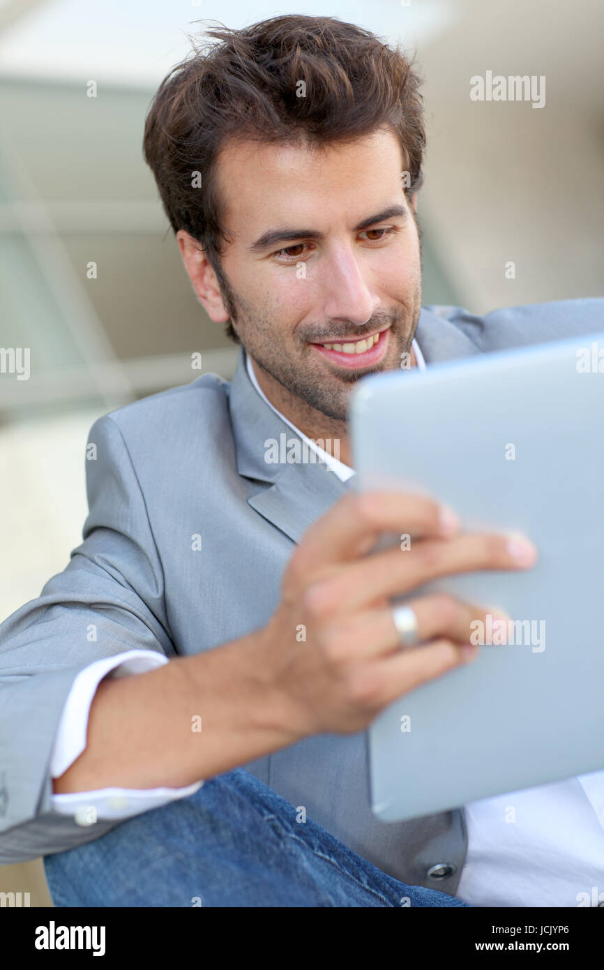 Portrait of smiling man using electronic tablet outside Stock Photo - Alamy