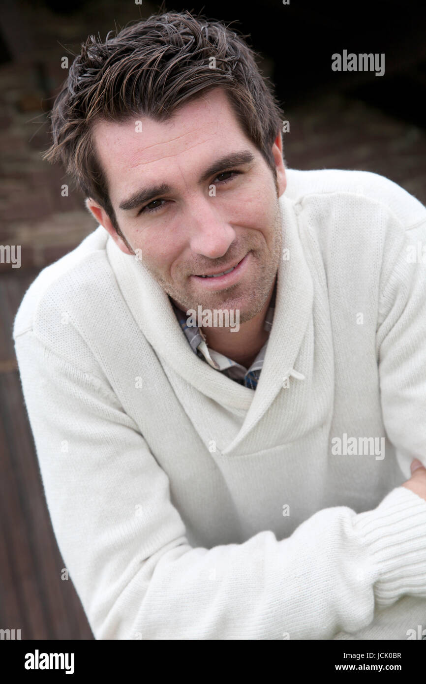 Smiling man standing in front of countryhouse Stock Photo - Alamy