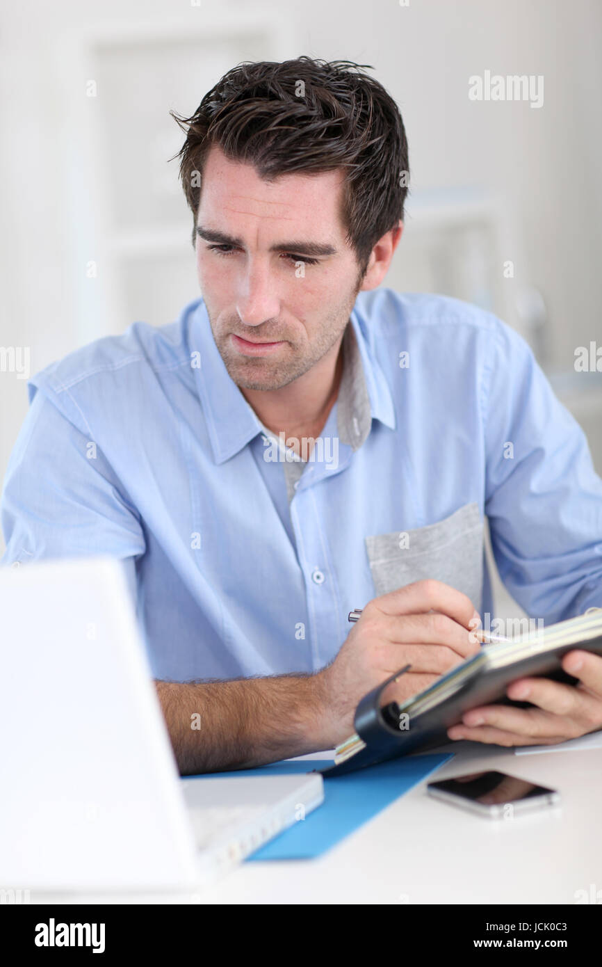 Office worker writing on agenda Stock Photo - Alamy