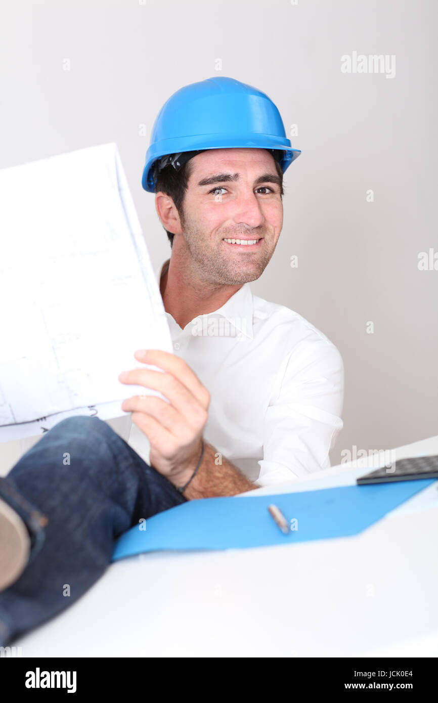 Relaxed architect in office with construction plan Stock Photo - Alamy