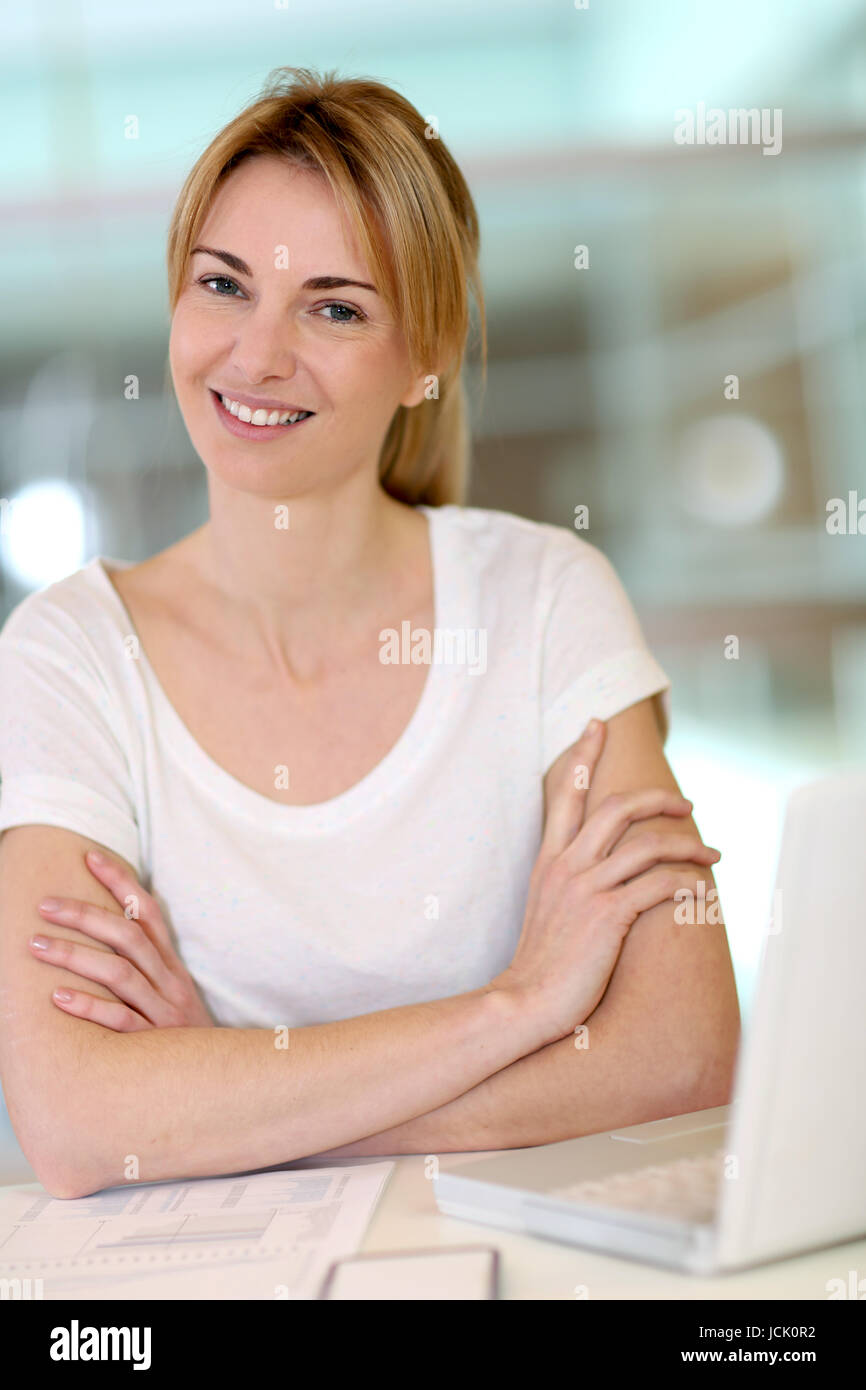 Portrait of office-worker sitting with arms crossed Stock Photo - Alamy