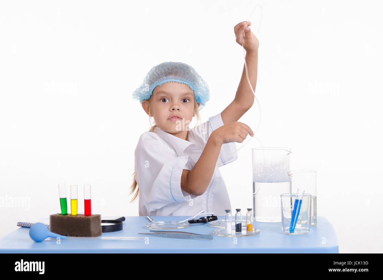 Chemist girl sitting at the table with the reagents in chemistry class ...