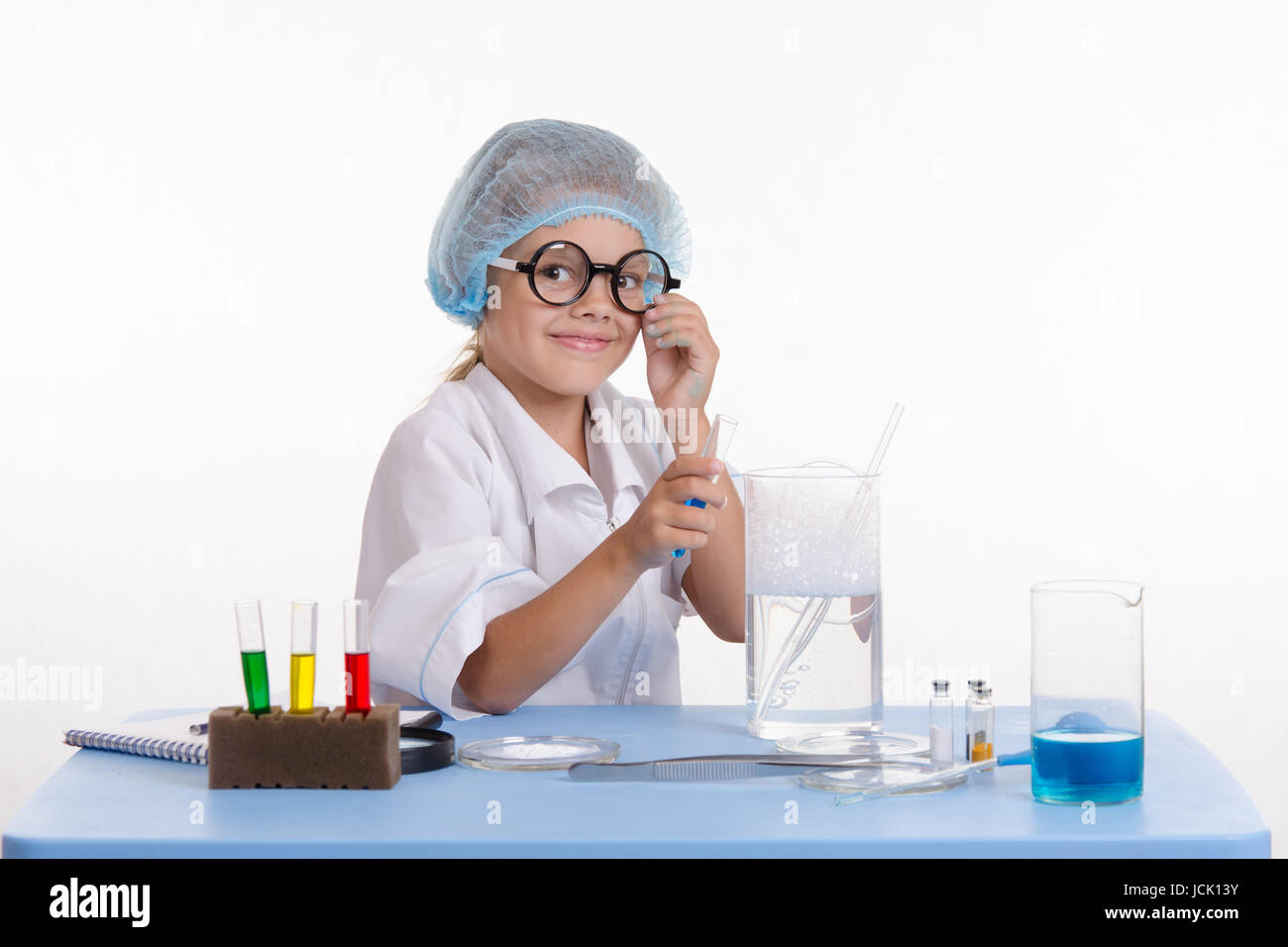 Chemist girl sitting at the table with the reagents in chemistry class ...