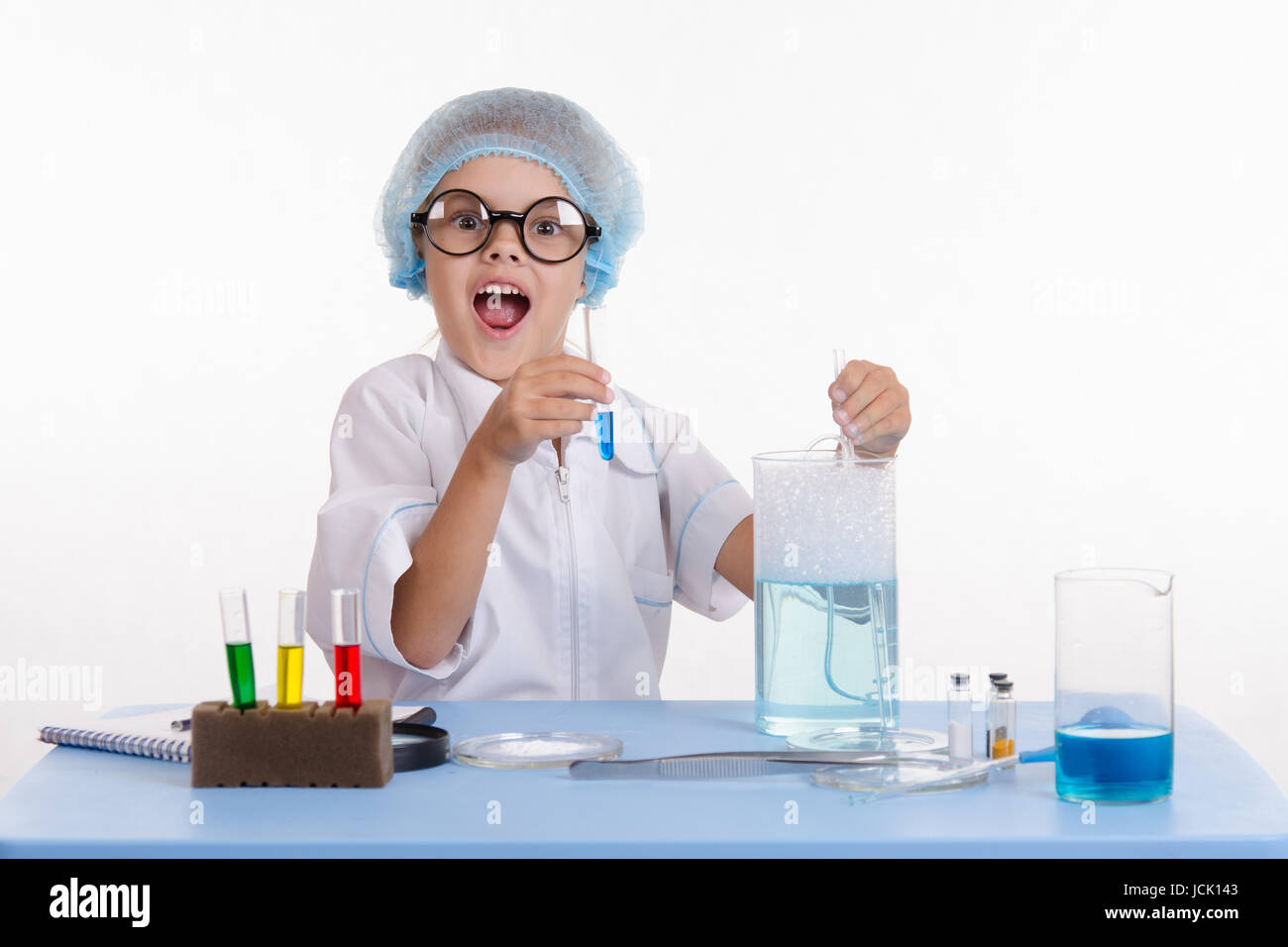 Chemist girl sitting at the table with the reagents in chemistry class ...