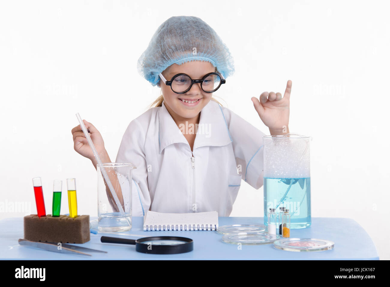 Chemist girl sitting at the table with the reagents in chemistry class ...