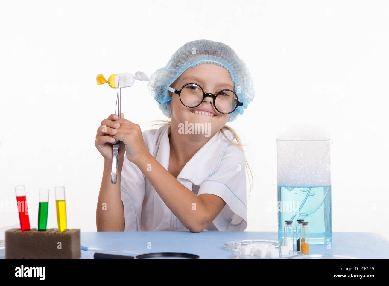 Chemist girl sitting at the table with the reagents in chemistry class ...