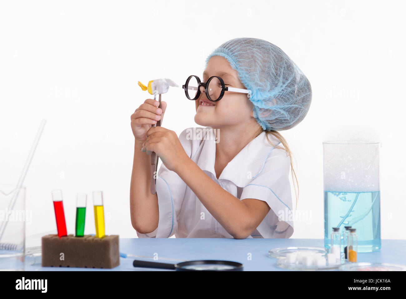 Chemist girl sitting at the table with the reagents in chemistry class ...