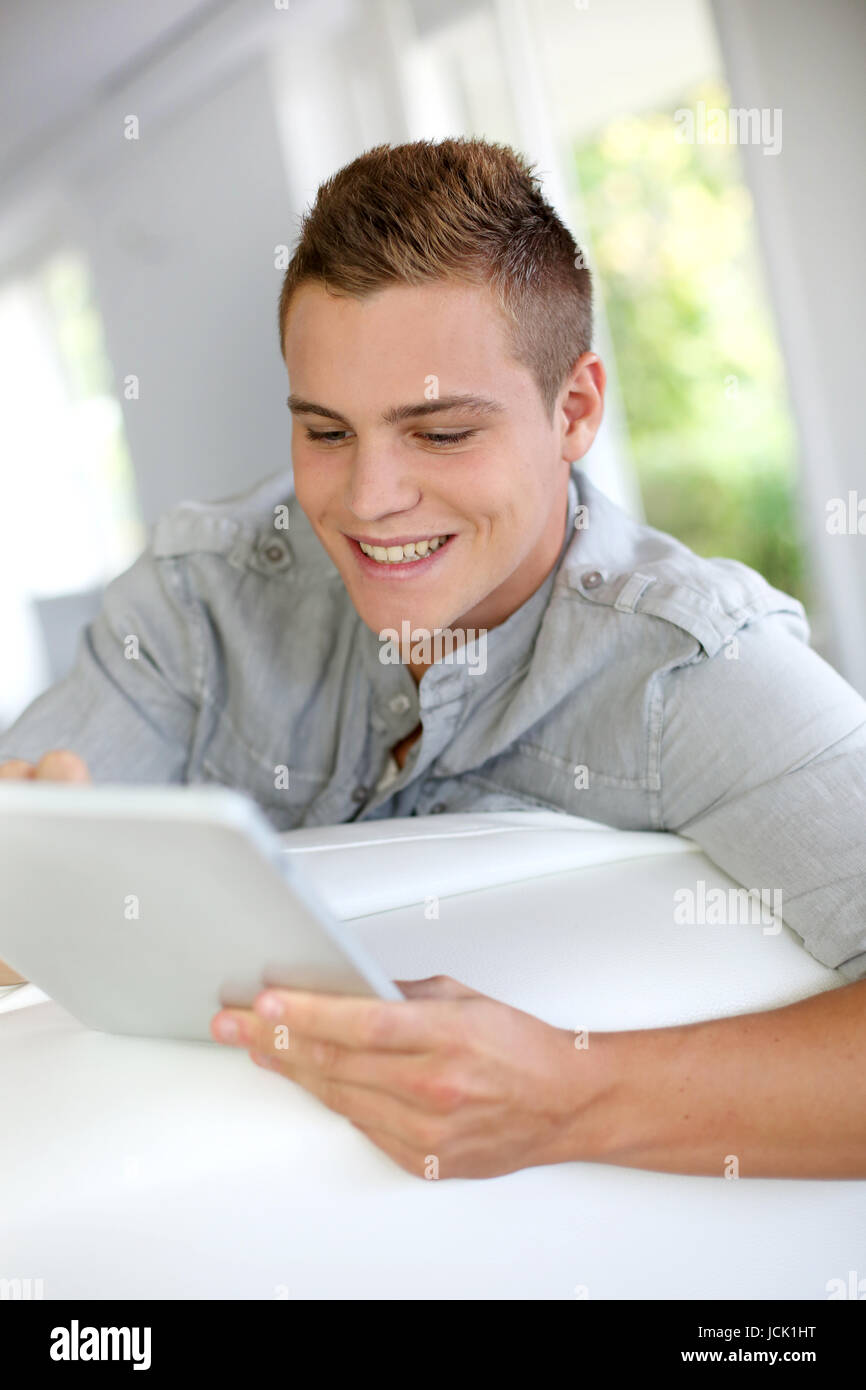 Young man using electronic tablet at home Stock Photo - Alamy