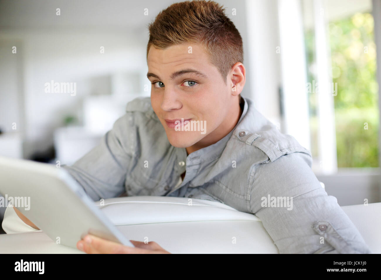 Young man using electronic tablet at home Stock Photo - Alamy