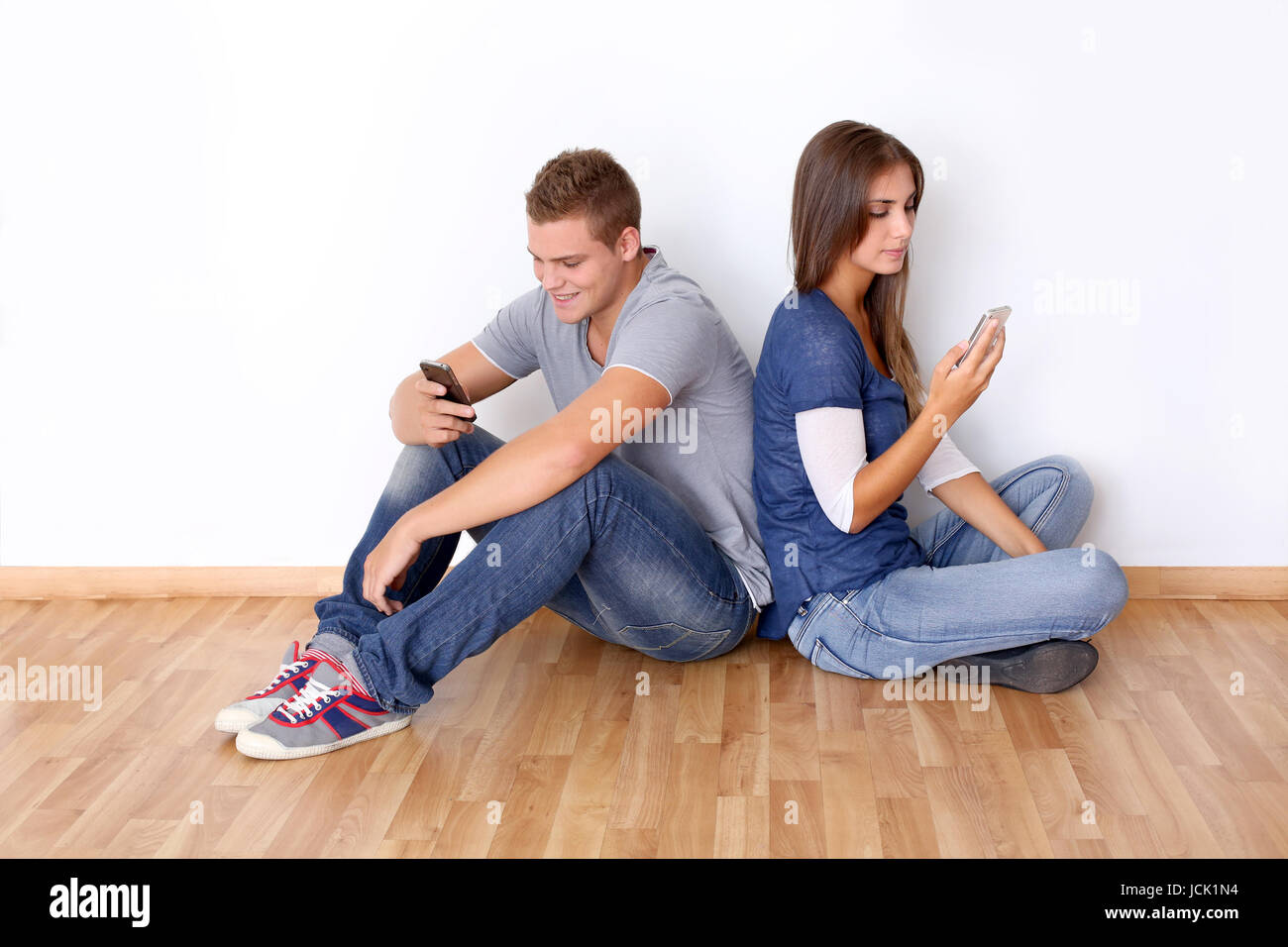 Young people sending messages with mobile phone Stock Photo - Alamy