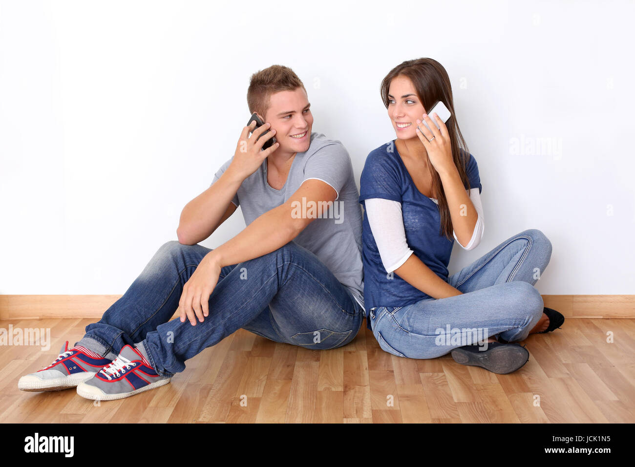 Young couple talking on mobile phone Stock Photo - Alamy