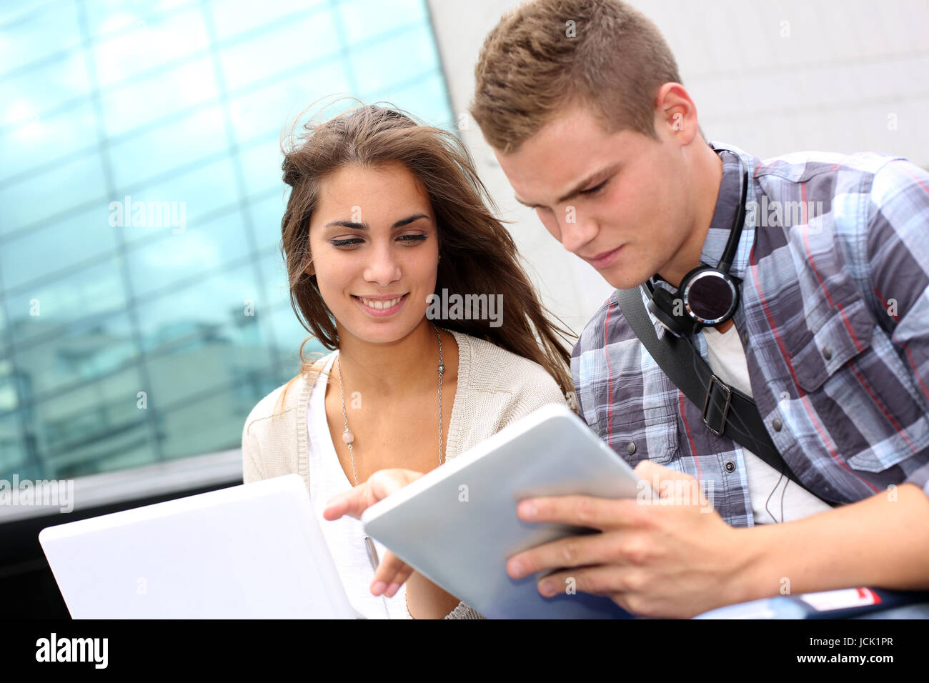 Students using tablet outside university building Stock Photo - Alamy
