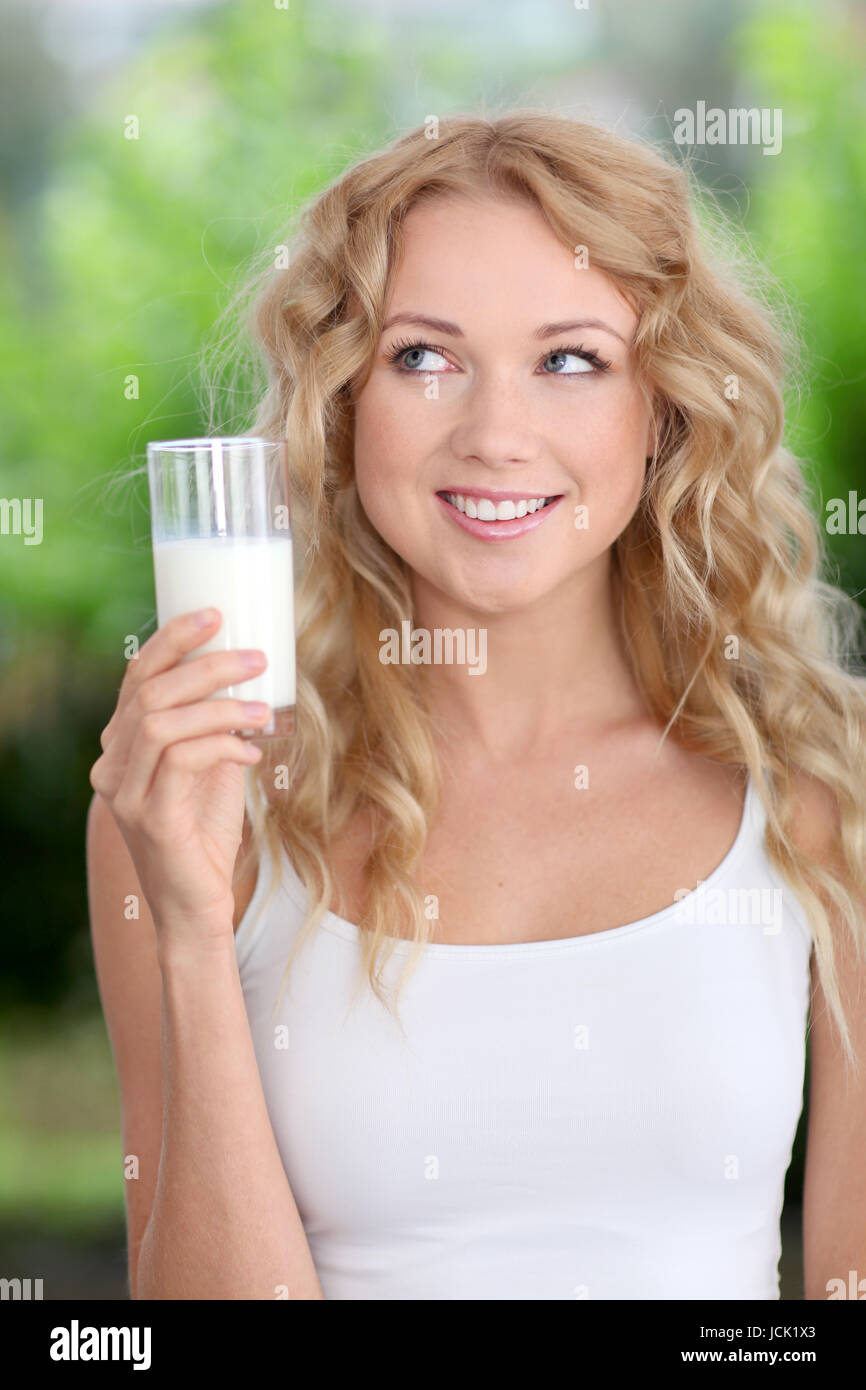 Blond woman drinking fresh milk Stock Photo - Alamy