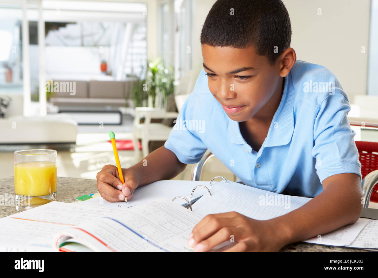 Boy Doing Homework In Kitchen Stock Photo - Alamy