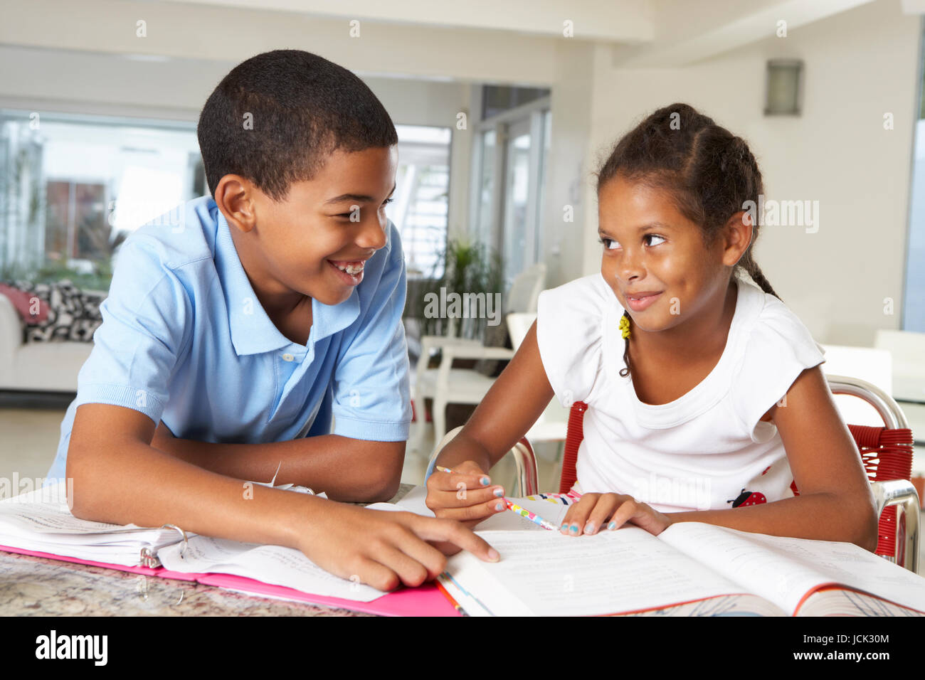 Two Children Doing Homework Together In Kitchen Stock Photo - Alamy