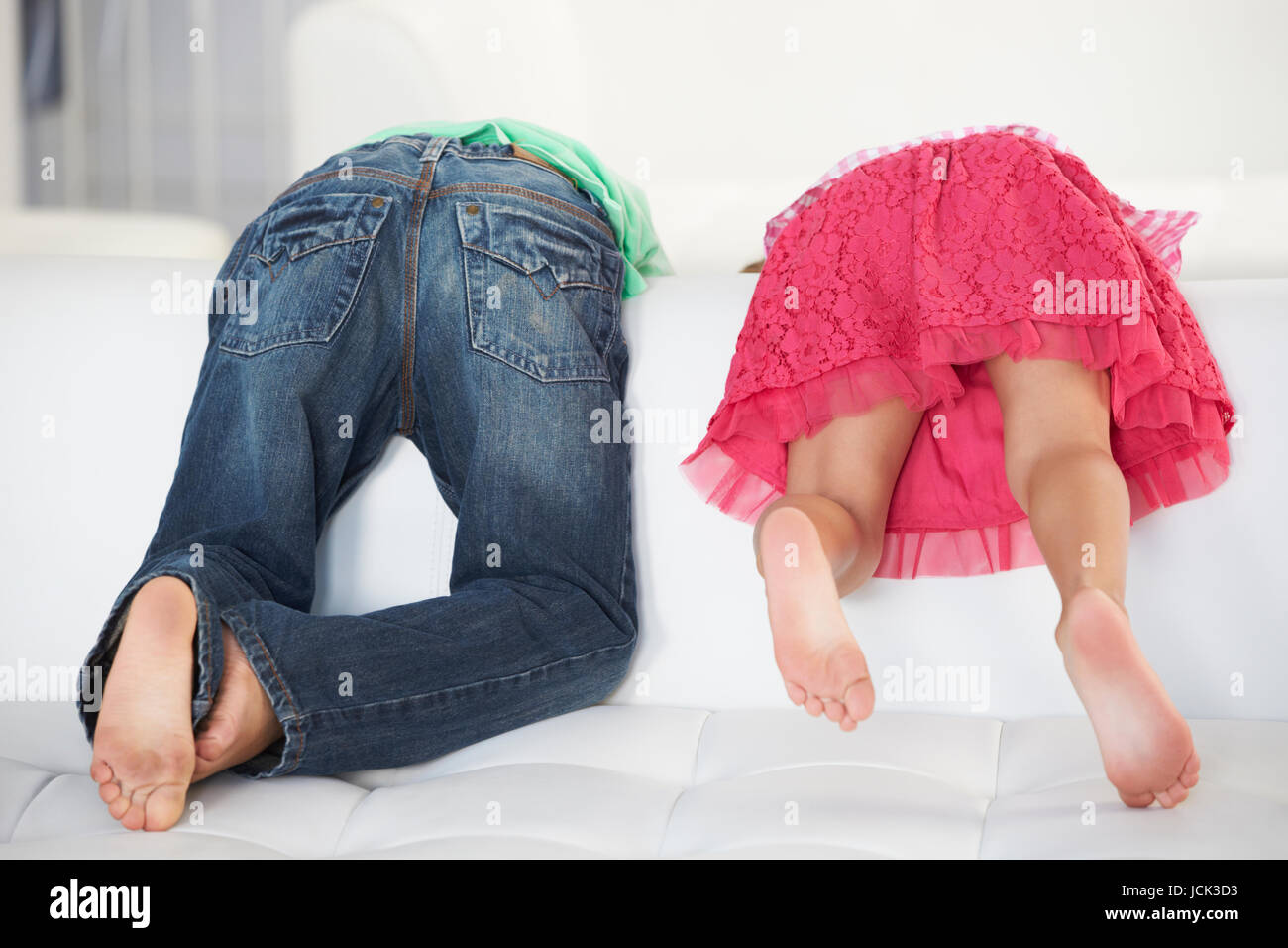 Rear View Of Two Children Playing On Sofa Stock Photo - Alamy