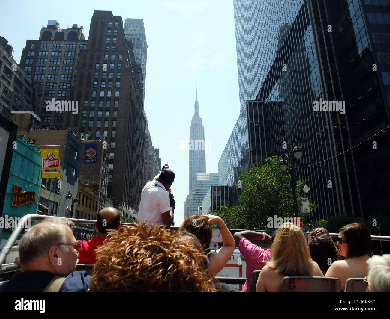 Tour bus ride through New York City with the Empire State Building off ...