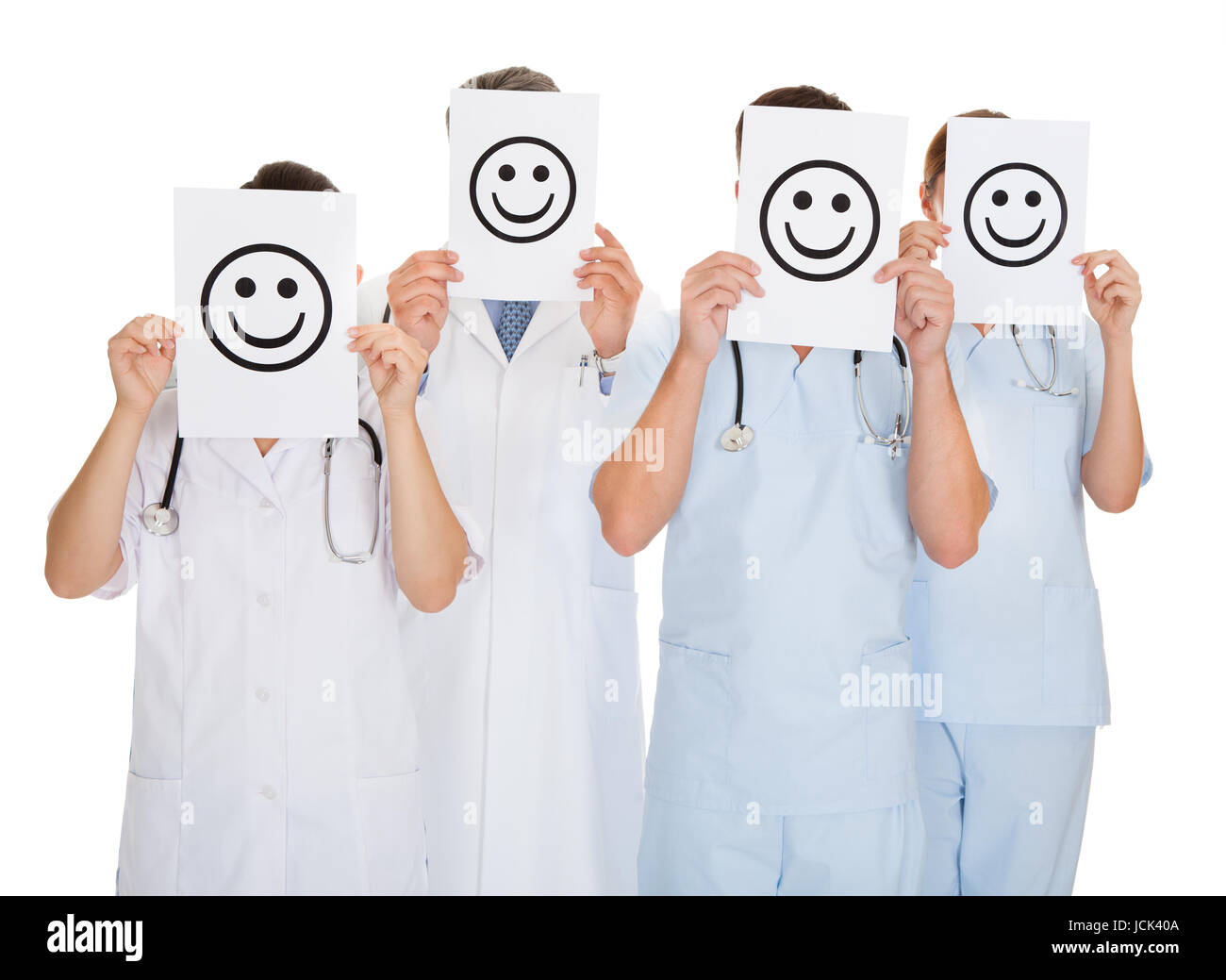 Team Of A Doctors Holding Smiley Icon Sign In Front Of Face Over White ...