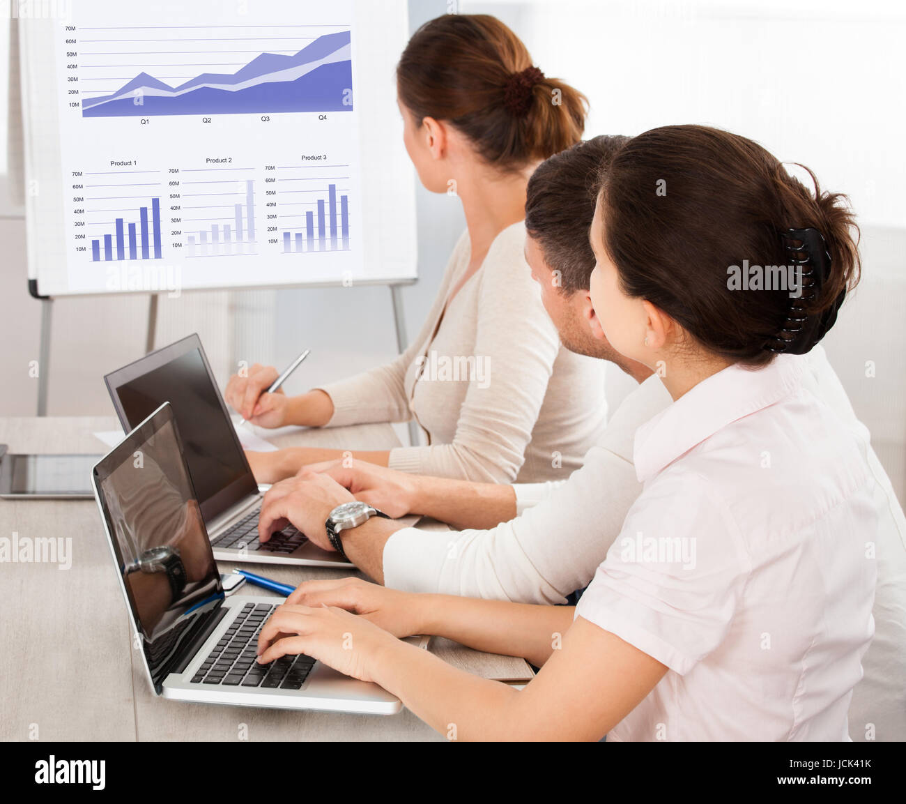 Group Of Business People Looking At The Graph On Flipchart Stock Photo ...