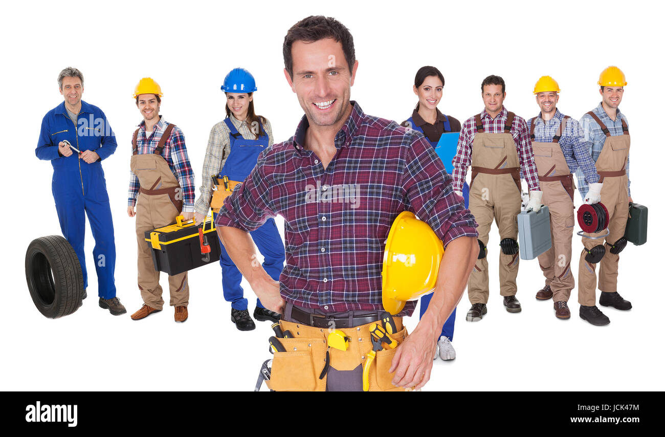Portrait of happy industrial worker standing in front of his team ...