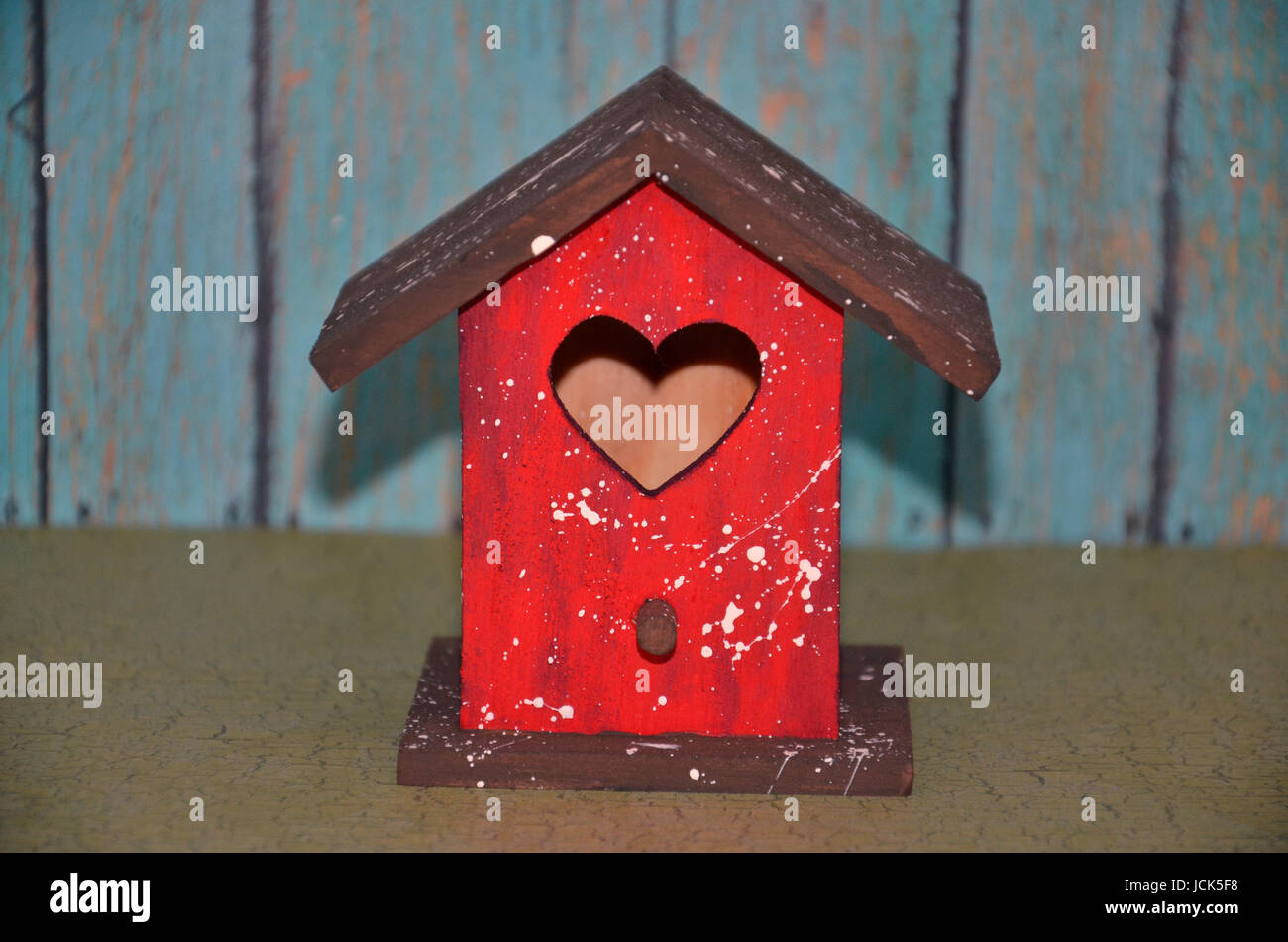 Red bird house with heart shaped opening Stock Photo - Alamy