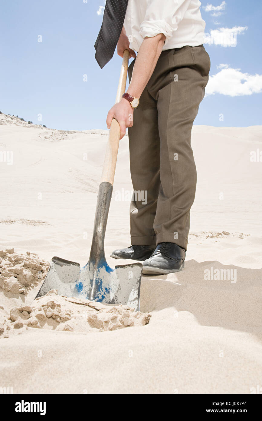 Man digging in desert Stock Photo - Alamy