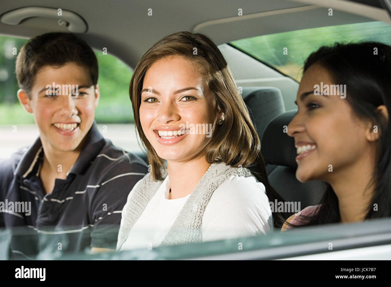 Three friends in the back of a car Stock Photo - Alamy