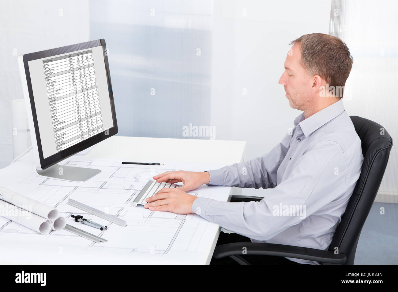 Portrait Of Mature Architect Using Computer At Office Desk Stock Photo ...