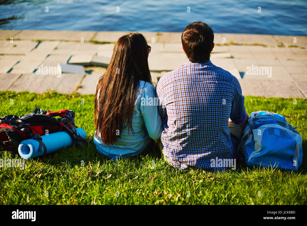 Romantic couple having rest on lawn with river in front Stock Photo - Alamy