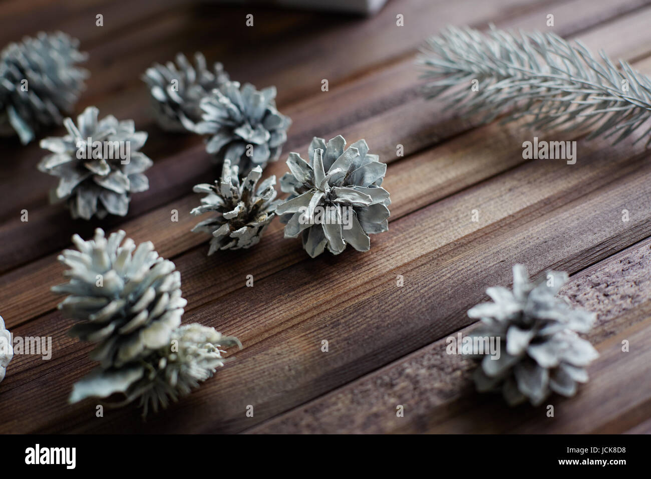 Several decorative silver cones and conifer on wooden background Stock ...