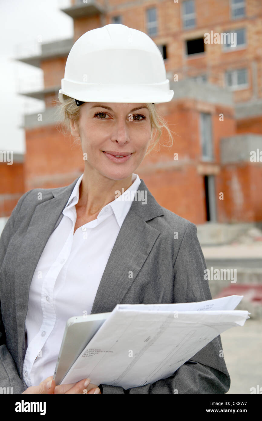 Woman engineer standing in front of building site Stock Photo - Alamy