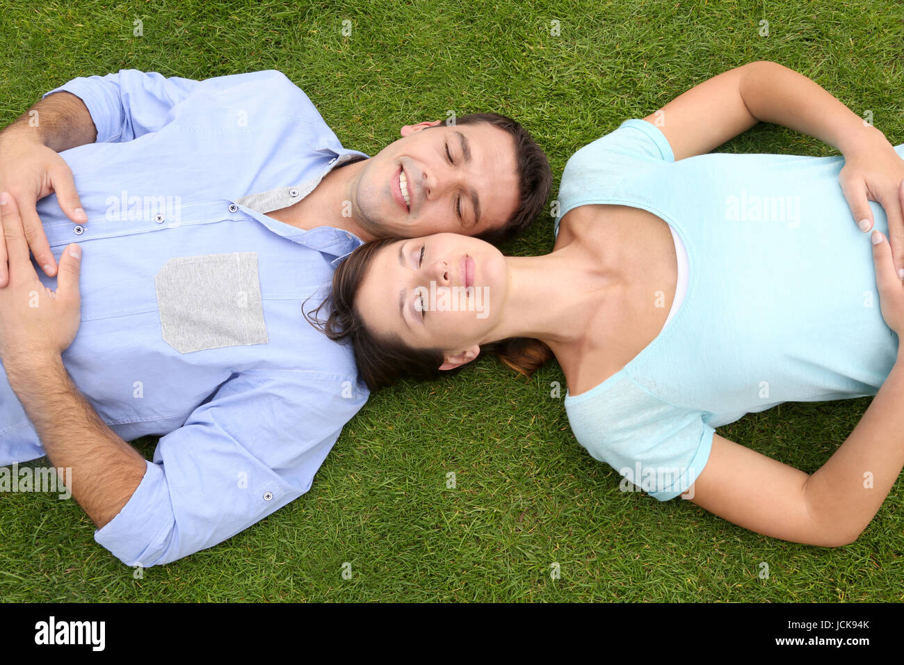 Top view of couple relaxing with eyes shut in grass Stock Photo - Alamy